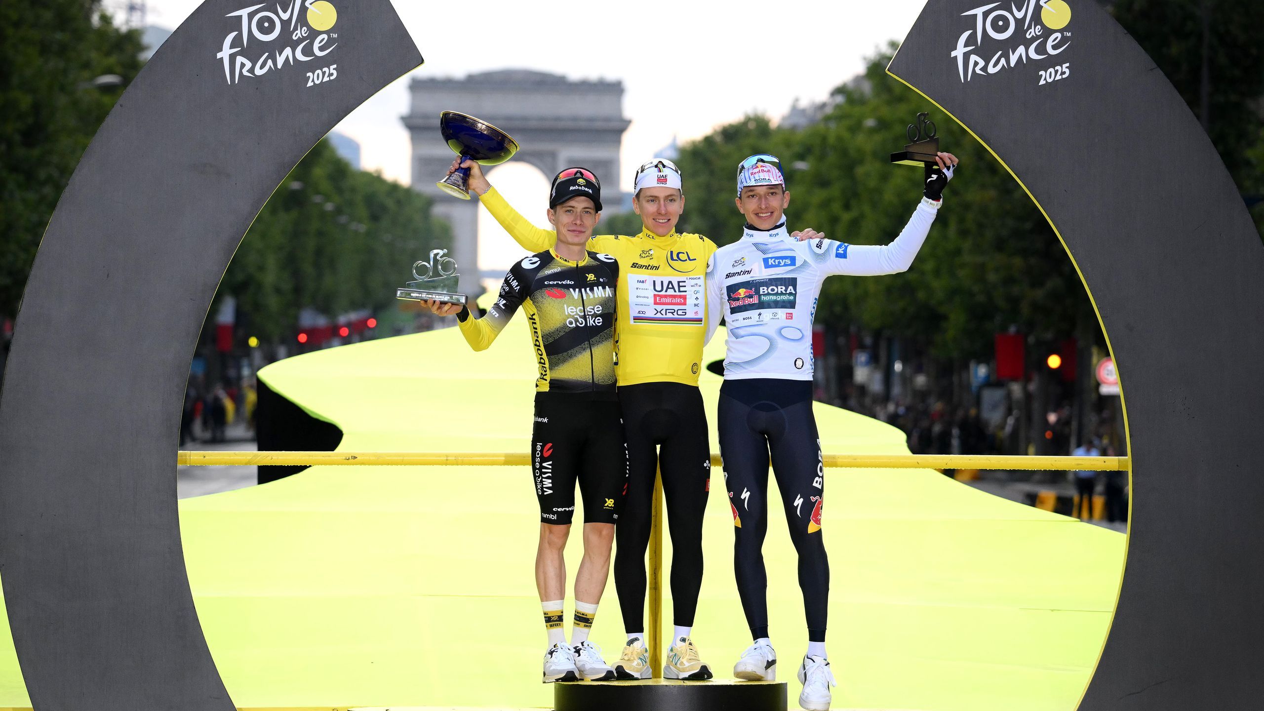 Tour-winnaar Tadej Pogacar verlegen met een knipoog op het podium ...